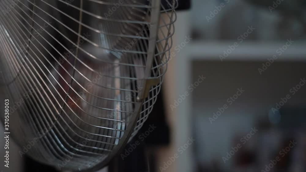 Standing traditional fan blowing air moving side to side during summer ...