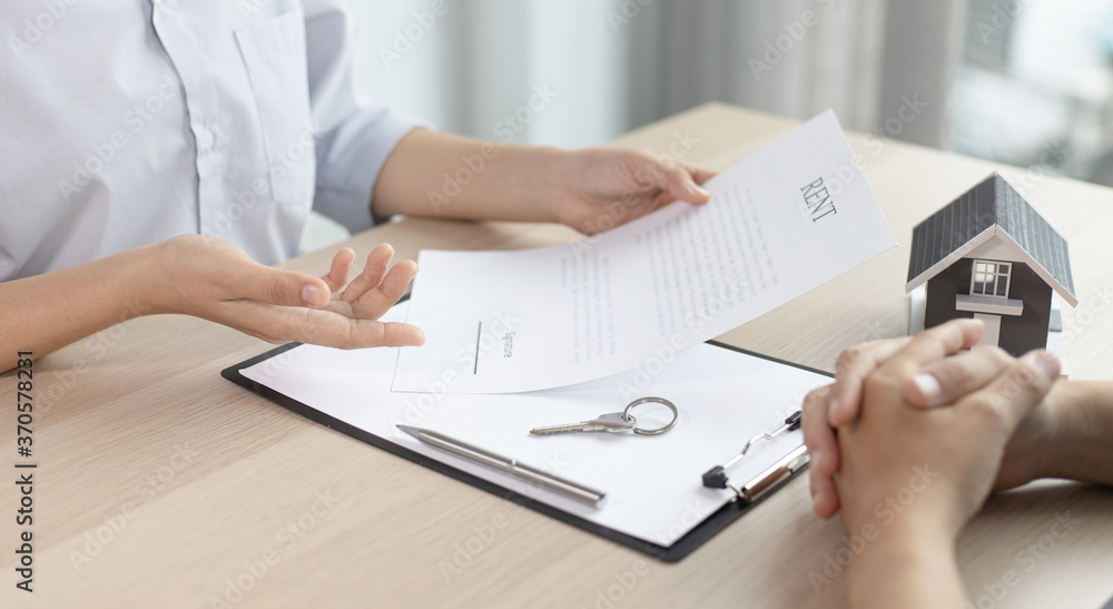 House salesman asks the customer to sign a house purchase contract and ...