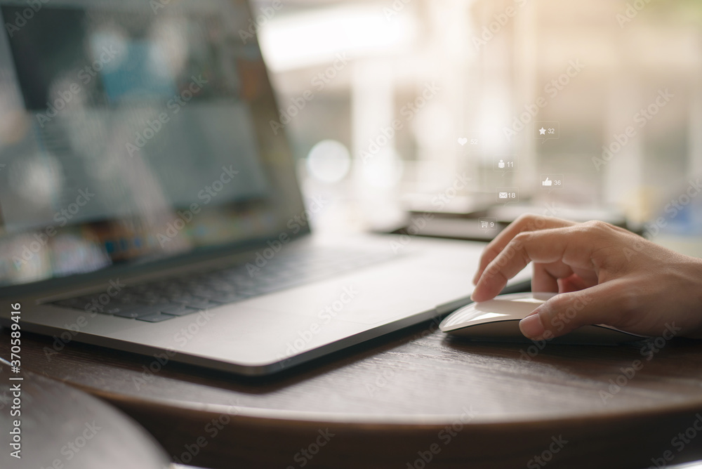 Female hand with computer mouse on table, hand using mouse and laptop ...