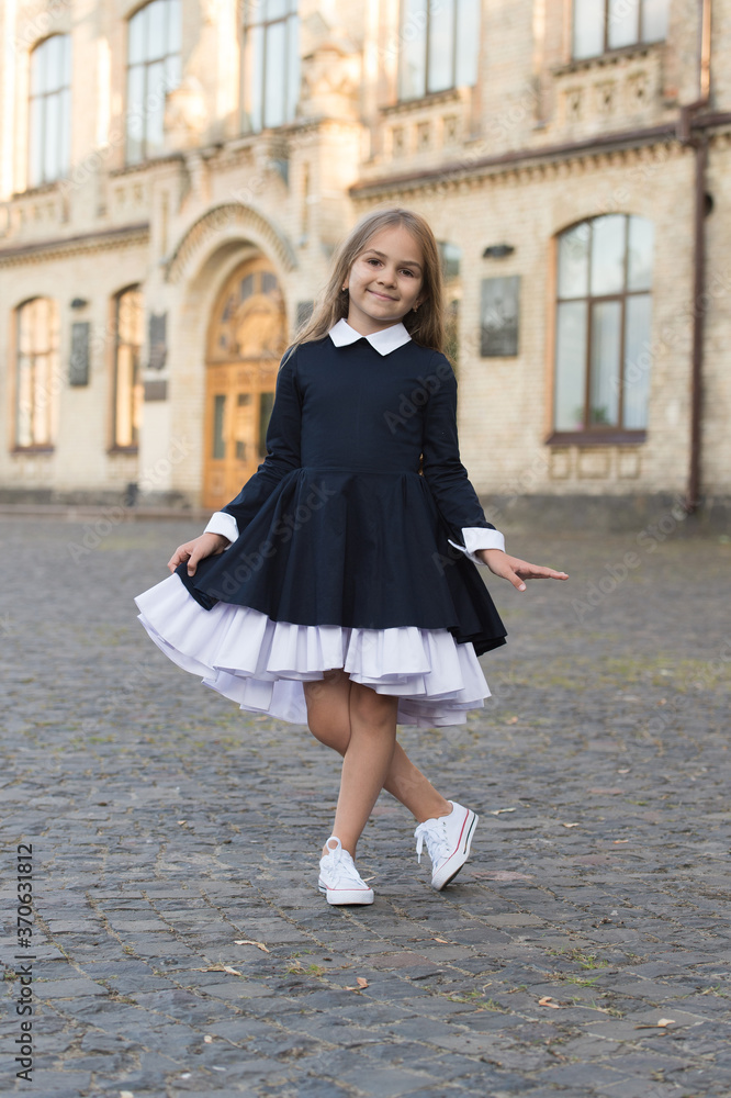 Its pleasure of elegance. Happy kid make curtsy in uniform outdoors ...