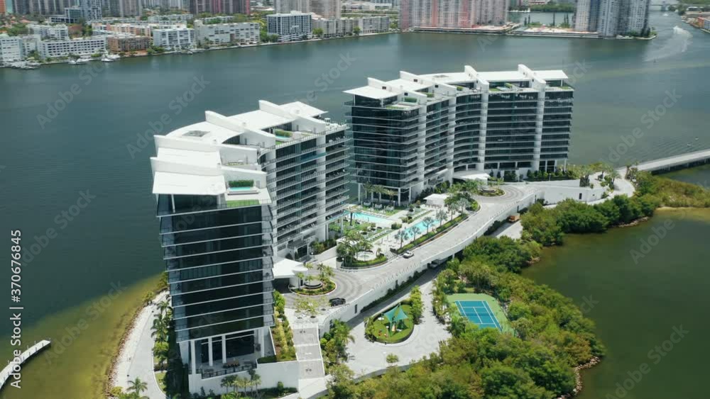 Modern design waterfront glass building on the green island in Miami ...