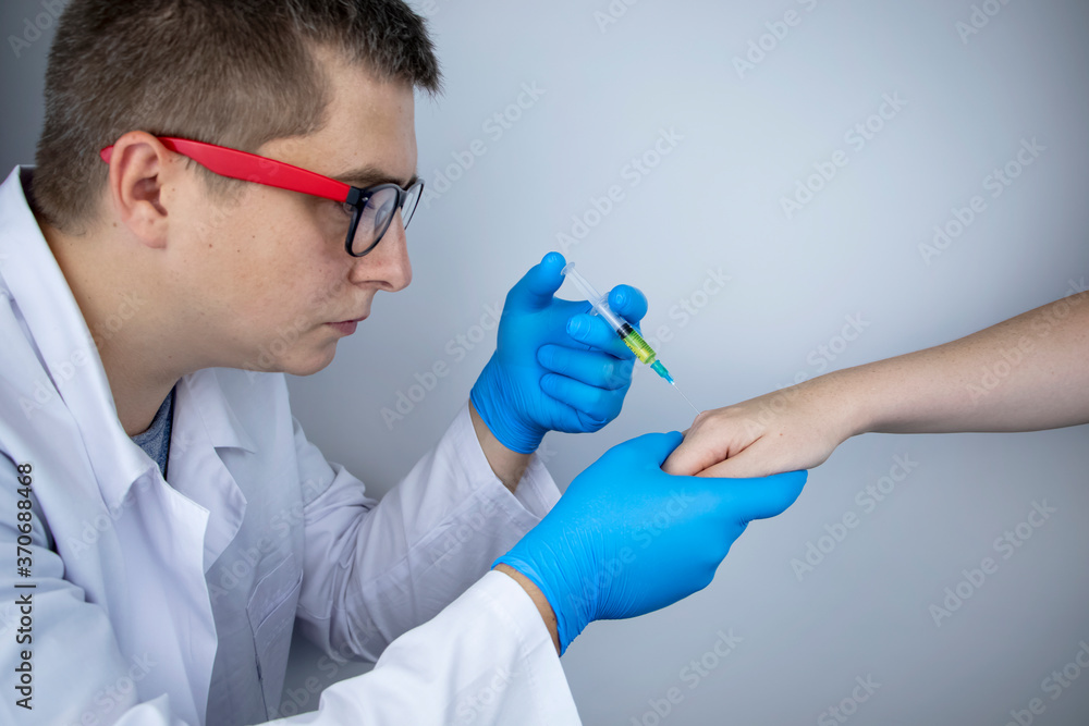 Orthopedic surgeon gives an injection in the finger joint. Treatment of ...