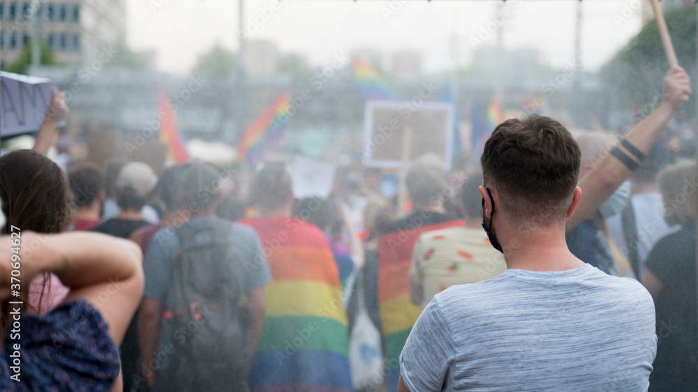 LGBT equality march. Young people wearing rainbow clothes and symbols ...