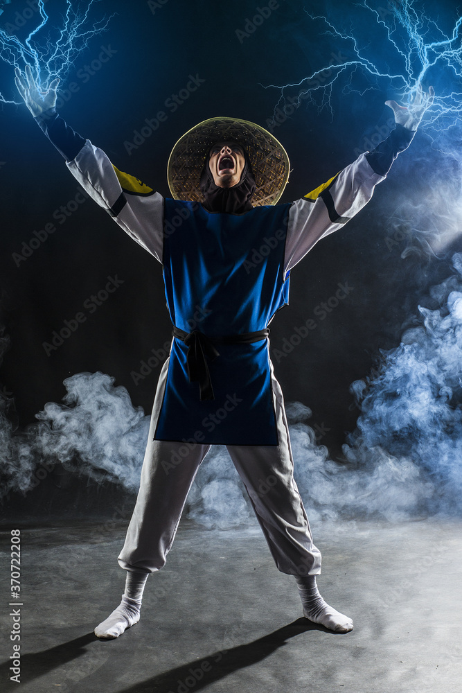 Cosplay a Shaolin monk in a straw hat raised his hands up out of his ...
