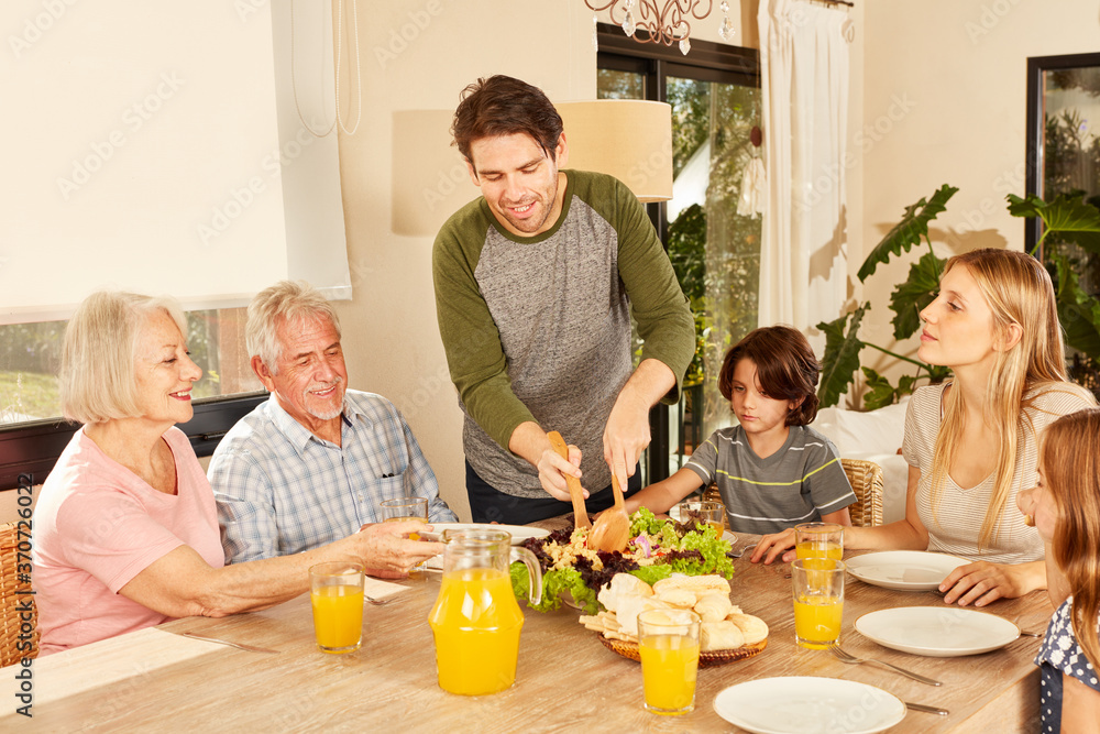 Großfamilie mit Kindern und Großeltern beim essen Stock Photo | Adobe Stock