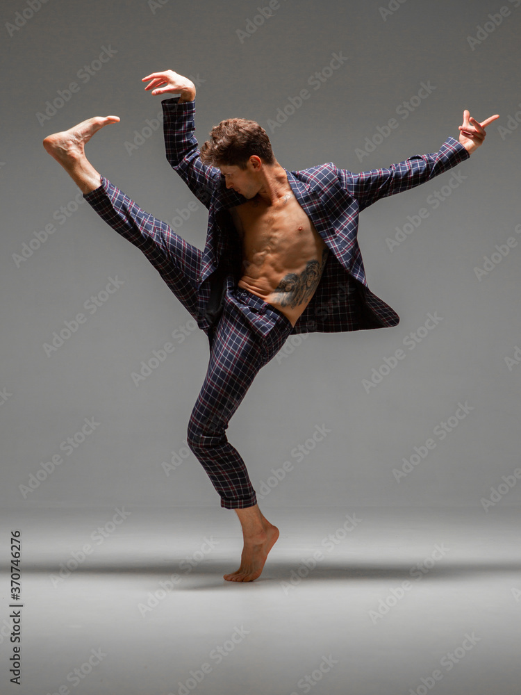Cool young man dancer dancing expressive dance in suit in studio. Dance ...