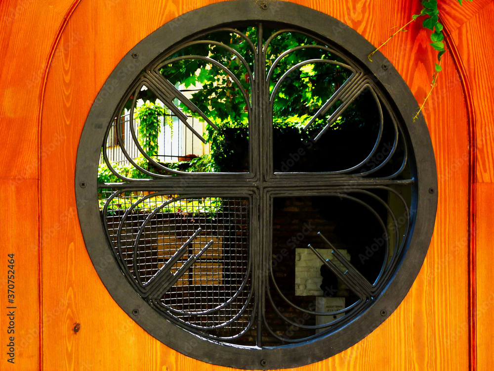 Round window opening in yellow stained pine wood exterior door with ...