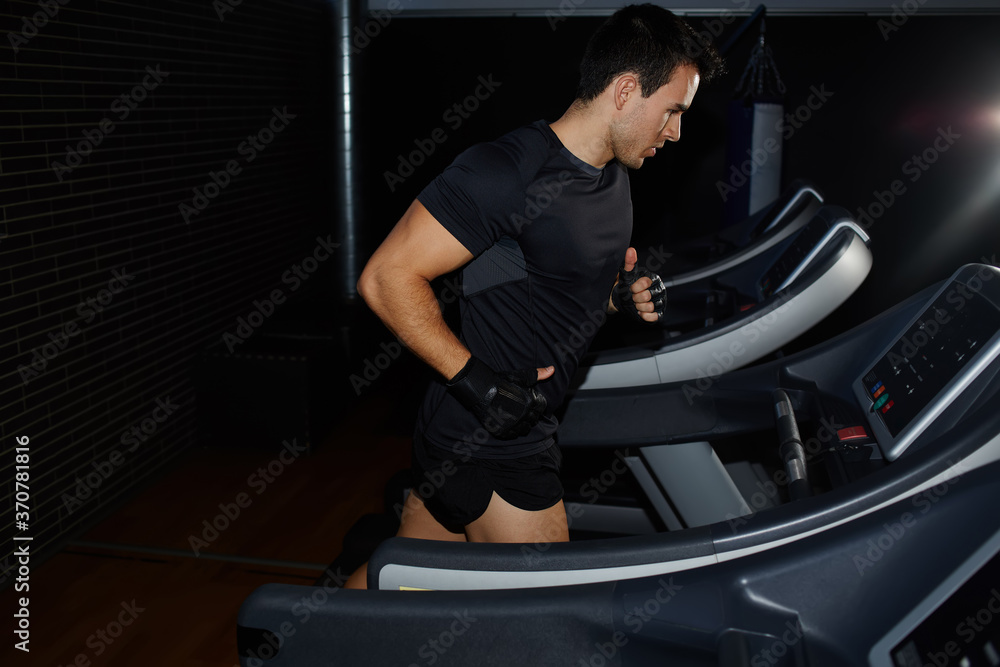 Handsome sportsman at the gym doing exercise on the treadmill, man ...