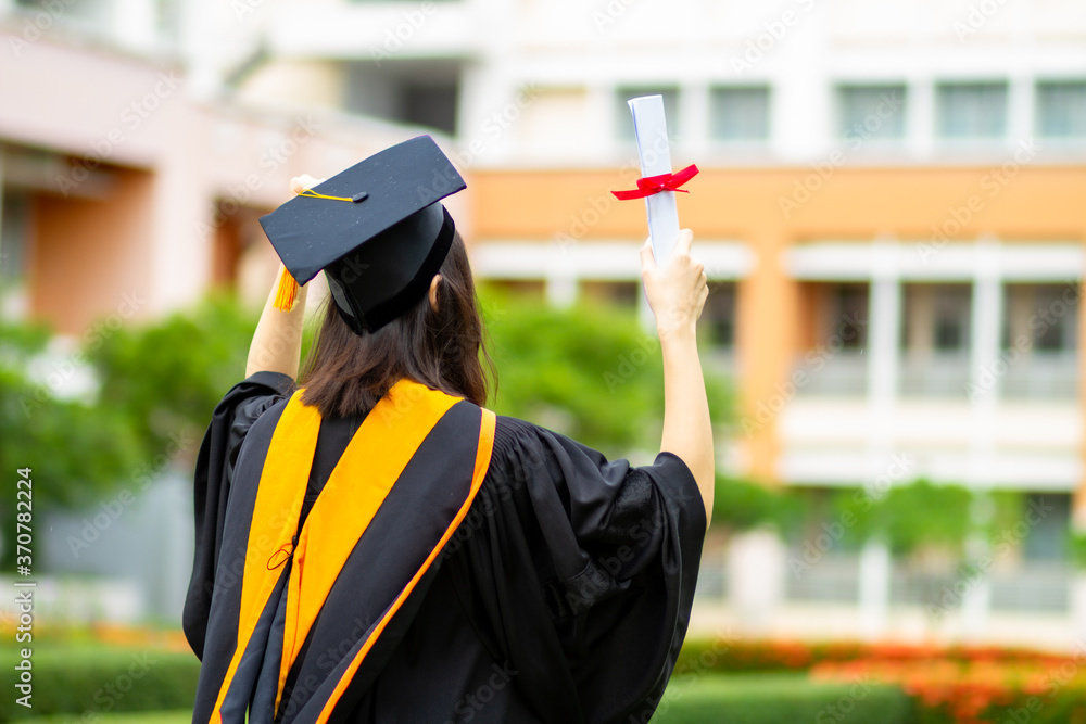Graduates raise their hands to celebrate graduation with diplomas and ...