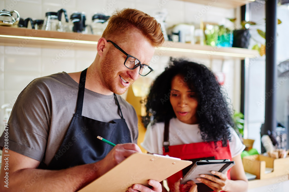 Two male and female partners working waiter and waitress in own coffee ...