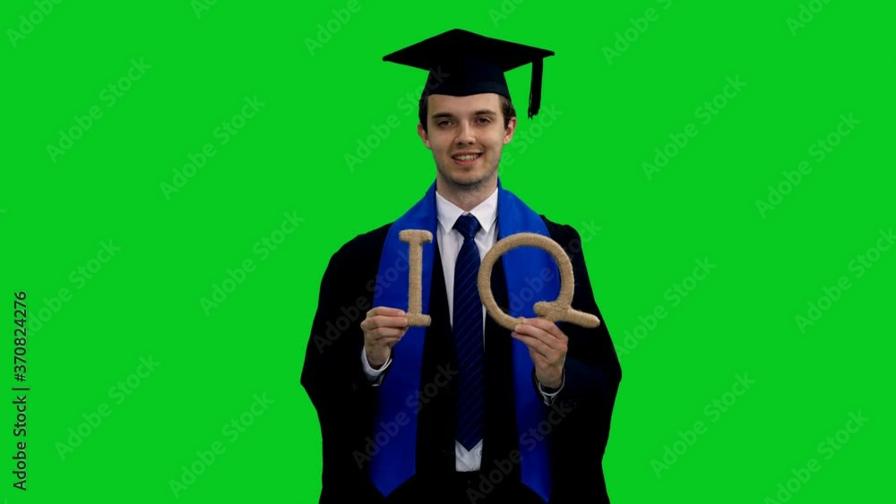 Smart graduating male student showing letters of iq symbol for ...