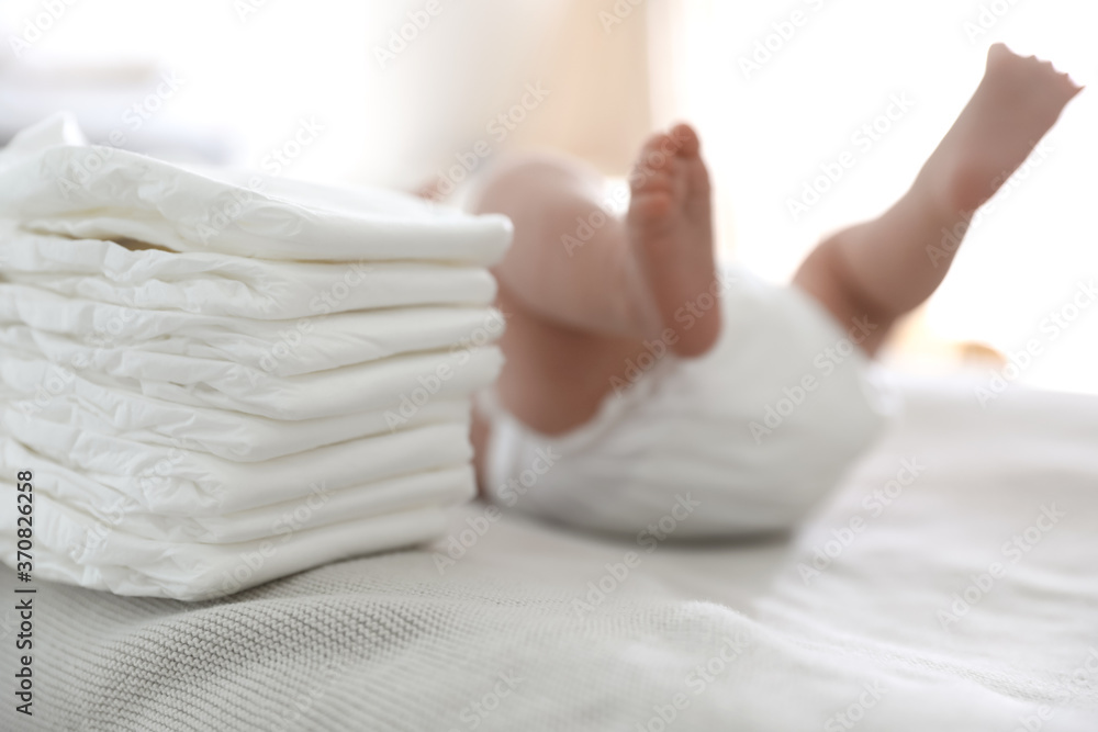 Cute little baby in diaper lying on bed in room, closeup Stock Photo ...
