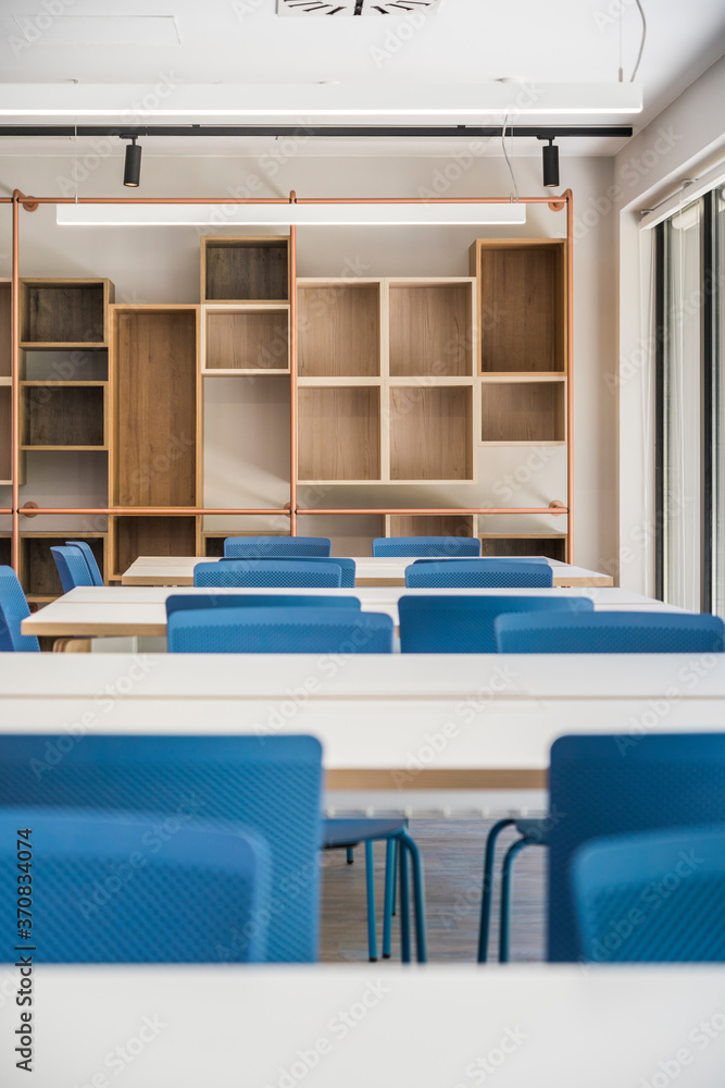 Modern style office interior with square tables and blue stools on ...