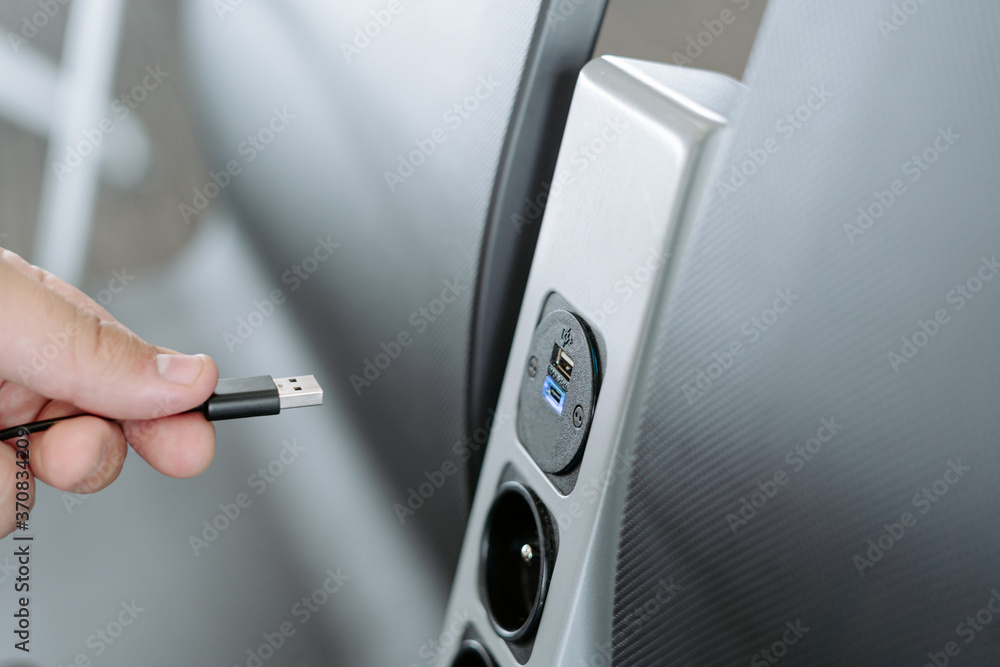 Crop unrecognizable male inserting black charging cable connector plug ...