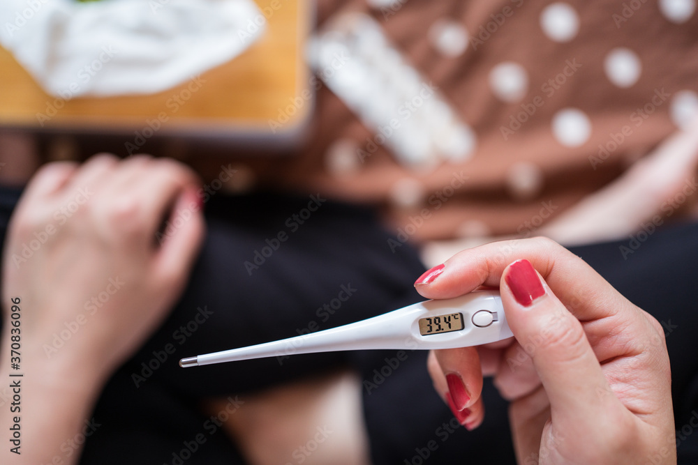 From above of unrecognizable female having high temperature and ...
