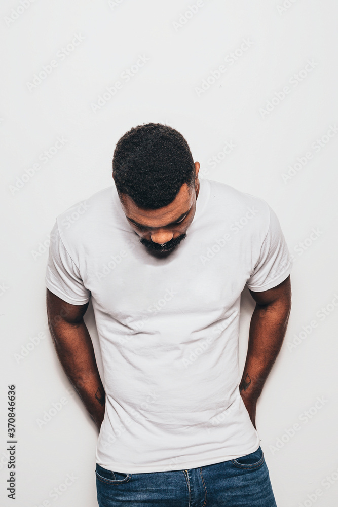 Serious black man with casual outfit posing over white background ...