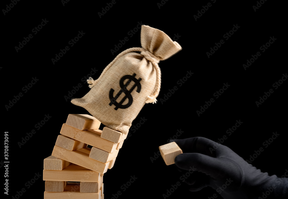 hand with black glove damaging the foundation of an US money bag and ...