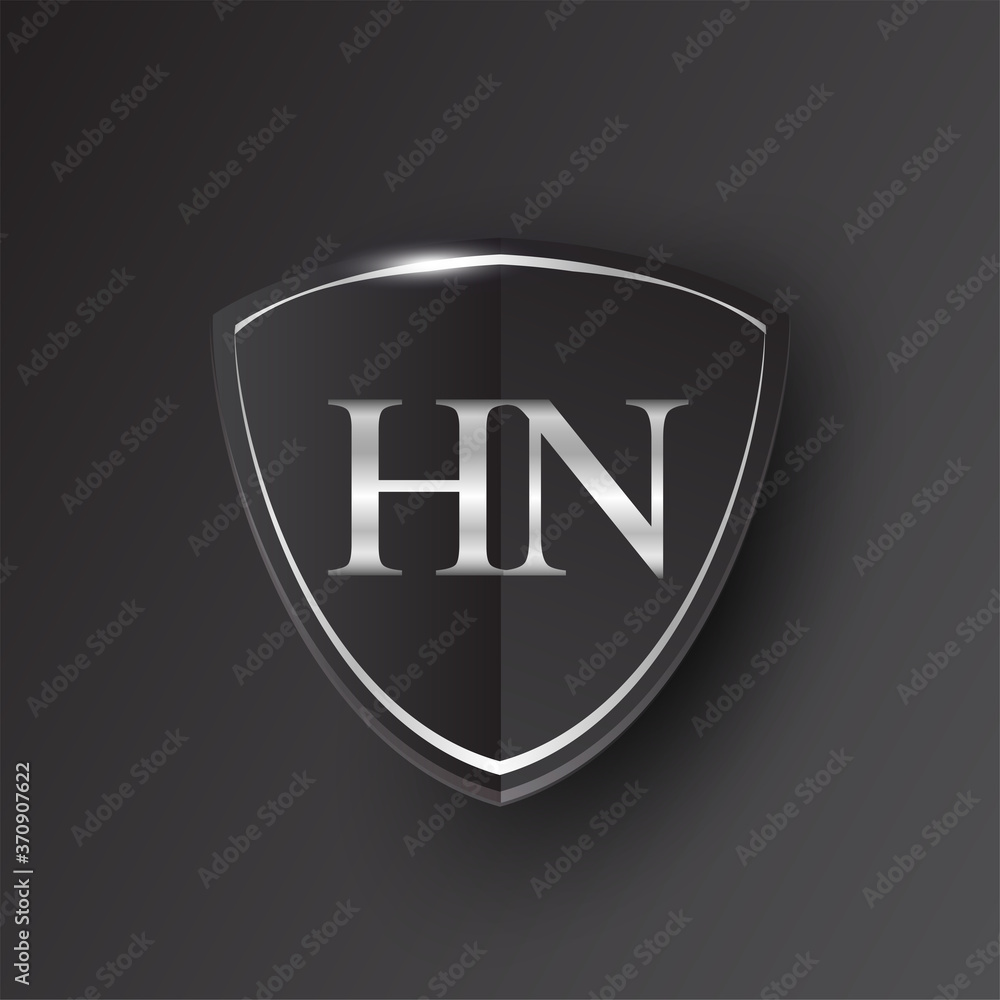 Initial logo letter HN with shield Icon silver color isolated on black ...
