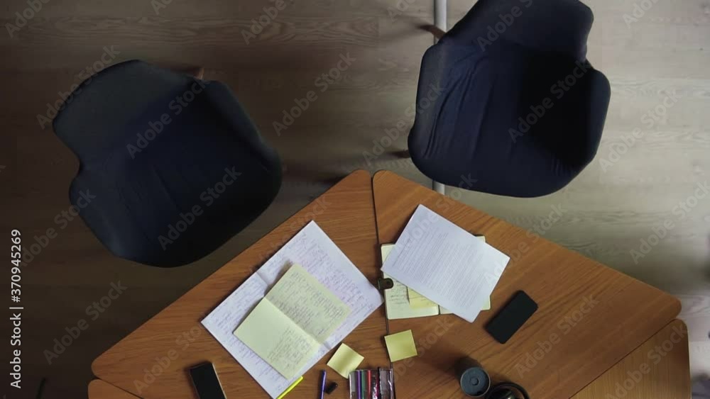 Two unrecognizable females coming and sit on chairs, starting hands ...