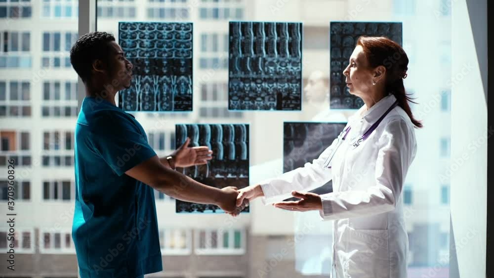 African American black man doctor in blue medic suit shakIng hands with ...