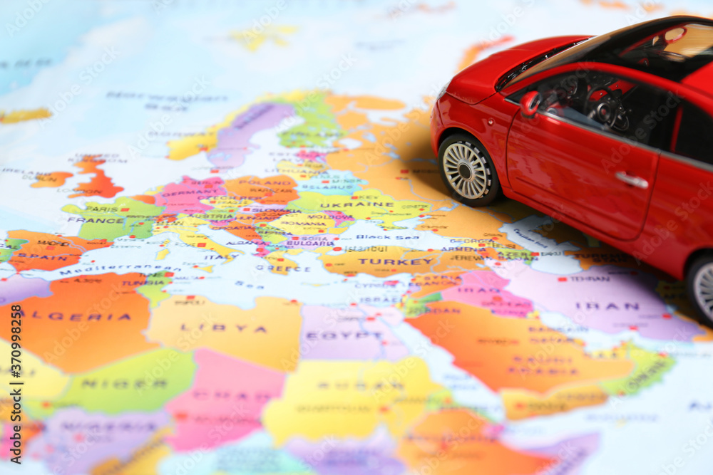 Red toy car on world map, closeup. Trip planning Stock Photo | Adobe Stock