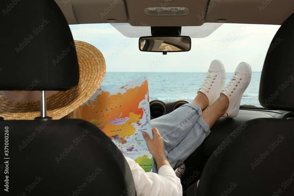 Young woman with world map in car, back view. Road trip Stock Photo ...