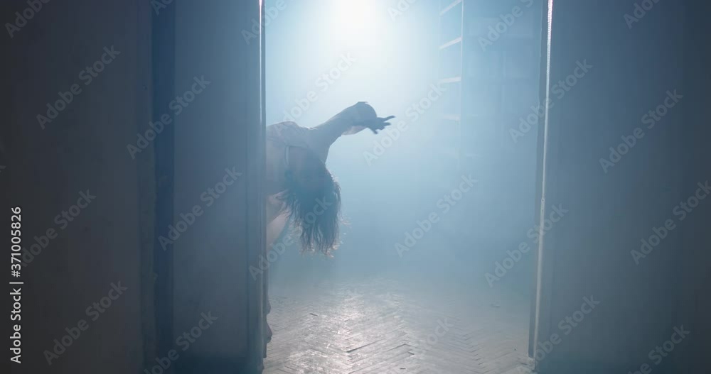 Creepy psycho girl in white smock agonizing and convulsing. Exhorcist ...