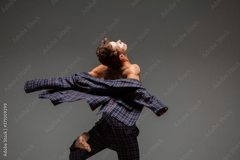Stylish young guy dancer in suit dancing modern expressive dance in ...