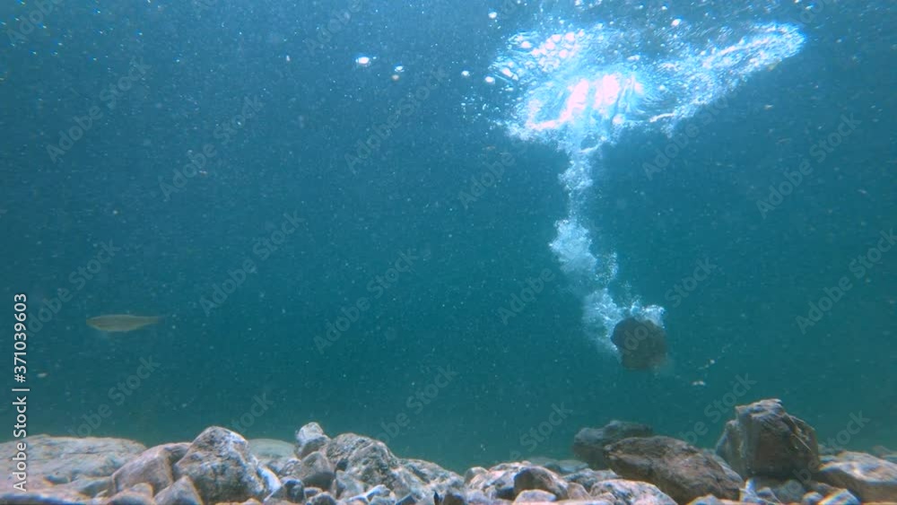 Rock falling in water. Underwater view of rocks bottom floor in ...