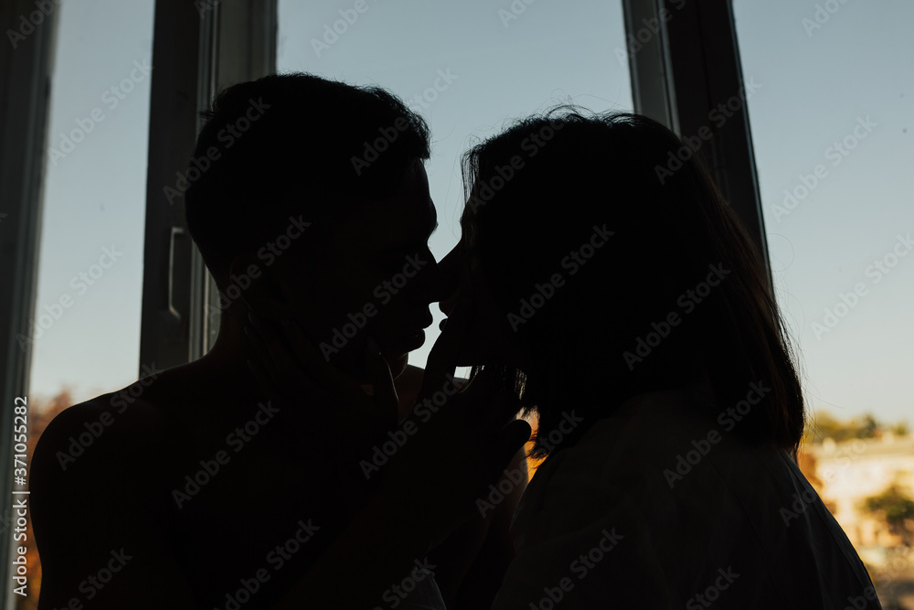 Silhouette of young loving couple is looking at each other. They ...