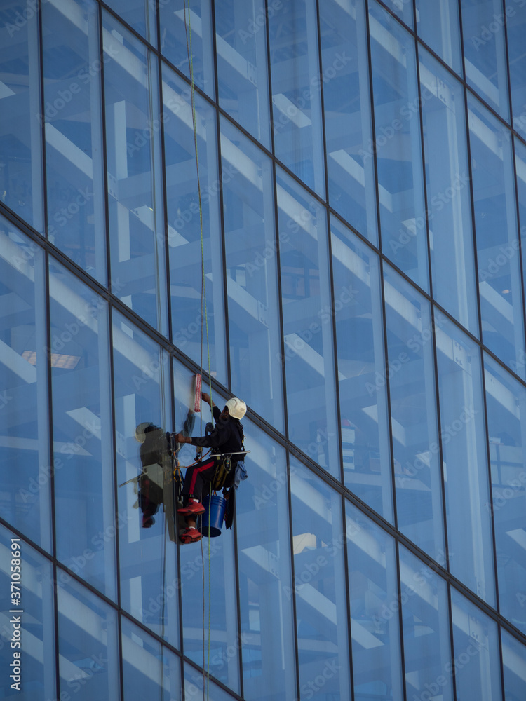 Window washer cleaning high rise building with large rectangular ...