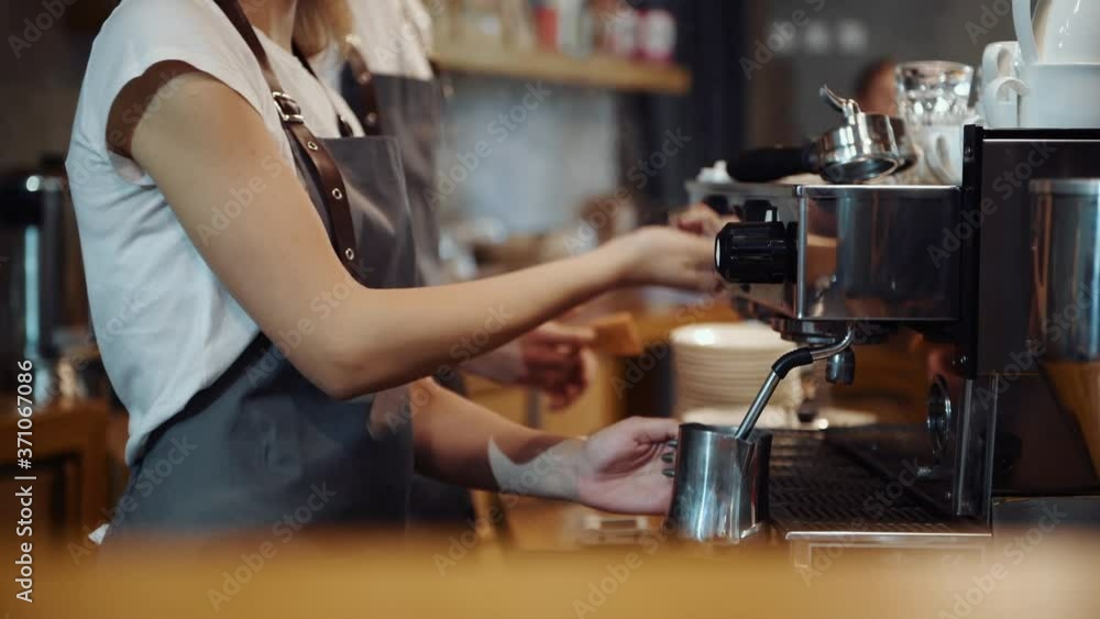 Cafe workers standing indoors and making fresh drink by using special ...