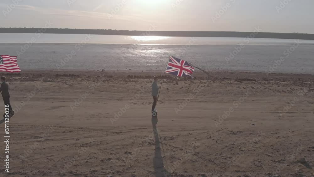 Two men with flags of the United States and Great Britain ride past ...