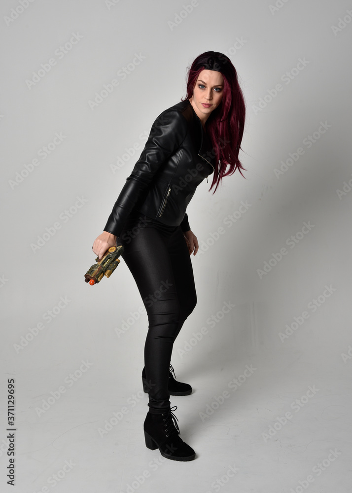 Full length portrait of girl with red hair wearing black leather jacket ...