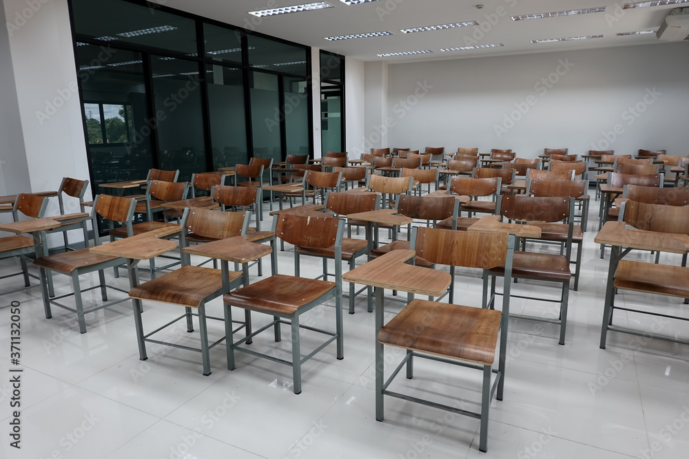 Empty school classroom with many wooden chairs. Wooden chairs in ...