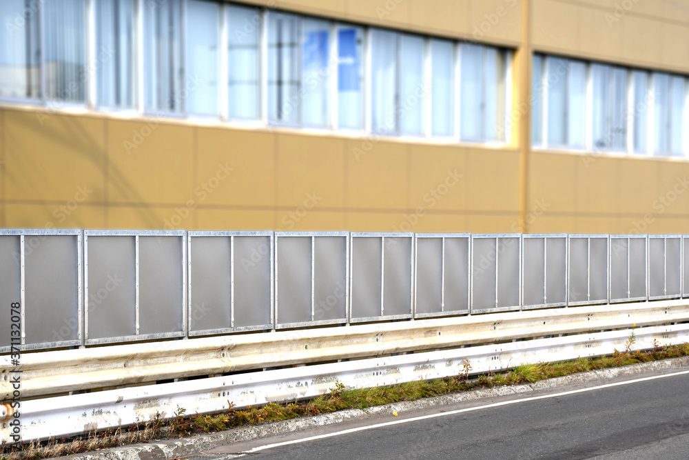 Noise barrier on the road in resident area, sound wall, sound berm or ...