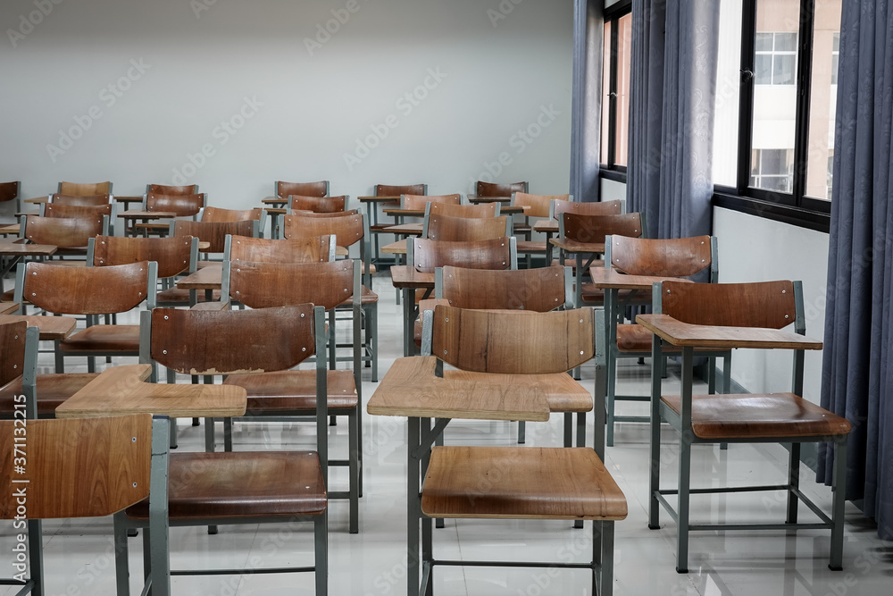 Empty school classroom with many wooden chairs. Wooden chairs in ...