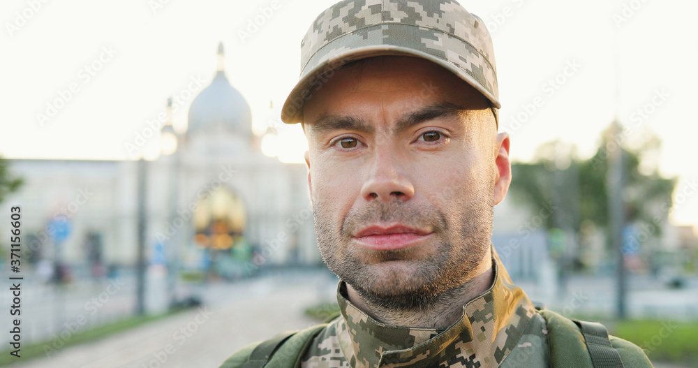 Portrait of serious Caucasian handsome young male soldier in cap with ...