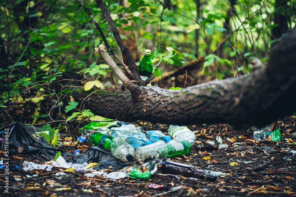 Foto de Garbage pile in forest among plants. Toxic plastic into nature ...