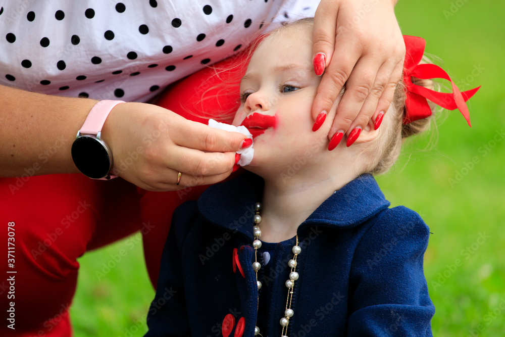 mom wipes face of little girl face stained with lipstick Stock Photo ...