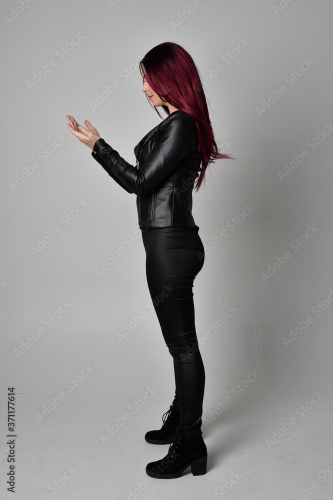 Full length portrait of girl with red hair wearing black leather jacket ...