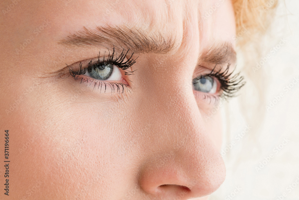 Squinting. Close up of face of beautiful caucasian young woman, focus ...