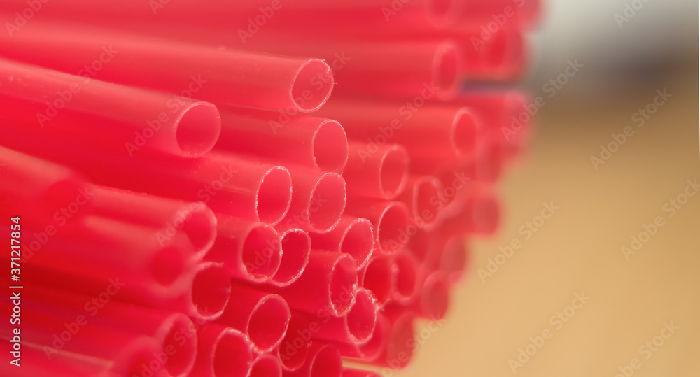 Abstract macro view of red plastic coffee stir sticks piled up ready to ...