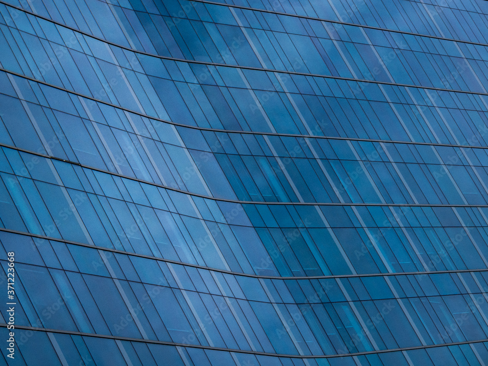 Abstract view of curved glass window panels on a commercial or ...
