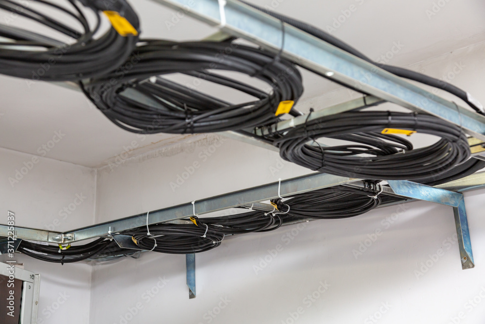 Cable management. Working wires, black cables wound into a coil, a ...