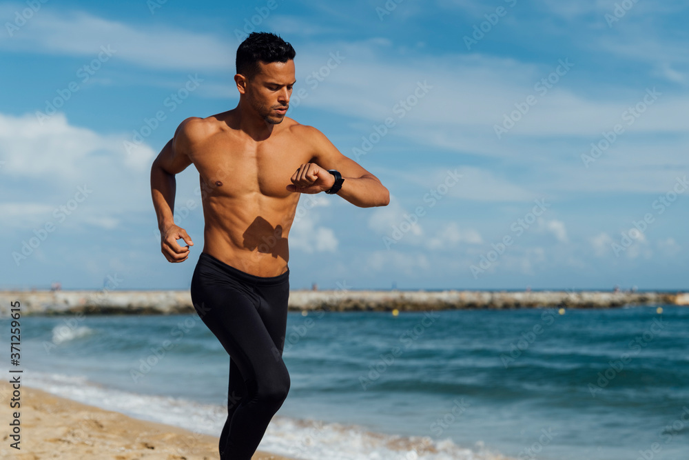 Man Running on the Beach Beside the Shallow Water . Side view of the ...
