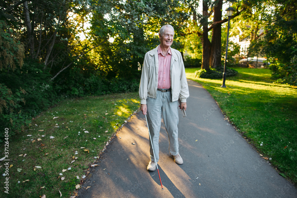 Visually impaired older man walking on path in nature Stock Photo ...