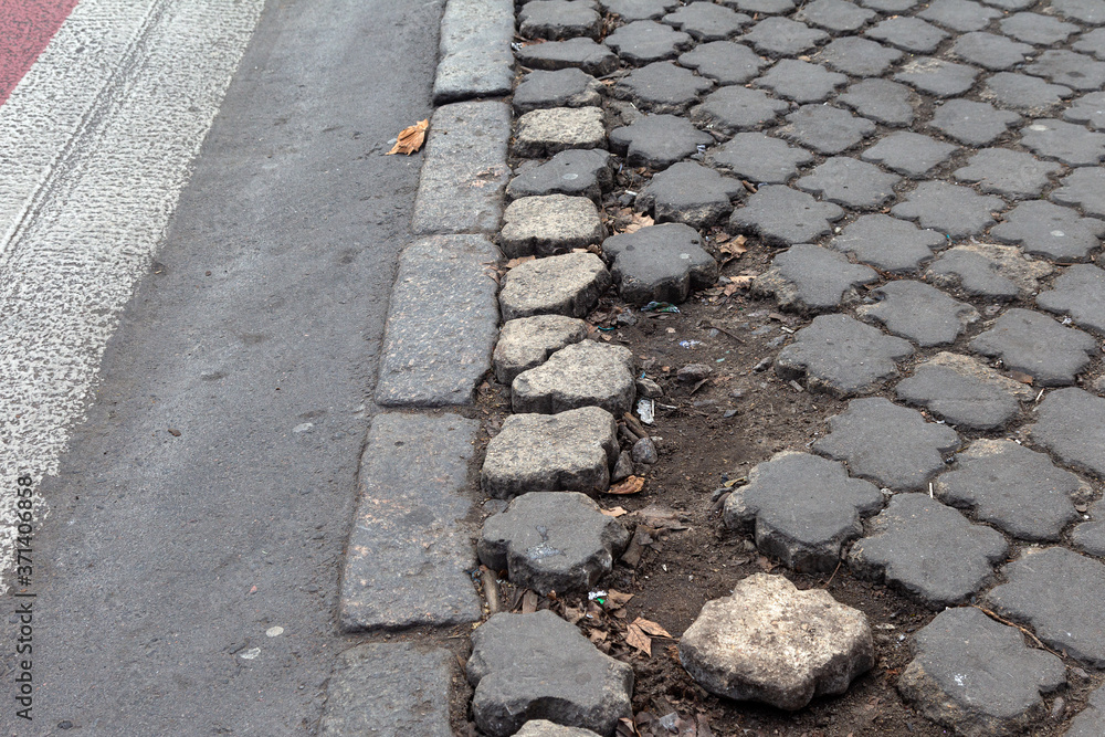 Damaged road with potholes, caused by freeze-thaw cycles in winter. Bad ...