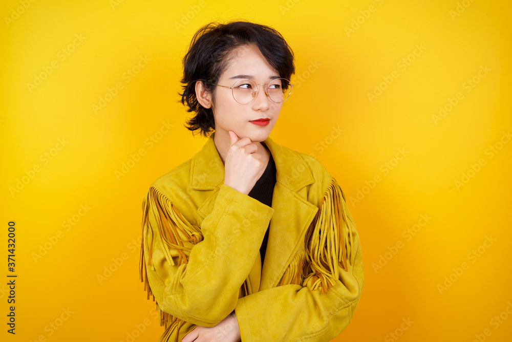 Shot of contemplative thoughtful Young woman keeps hand under chin ...