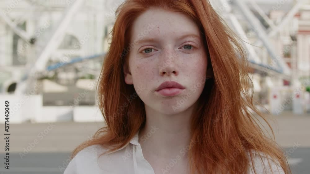 Attractive red-haired young woman with cute face freckles looking ...